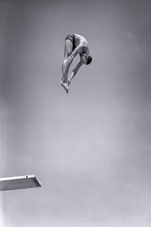 '1960s MAN JUMPING OFF DIVING BOARD TOUCHING TOES DOING FORWARD DIVE IN ...