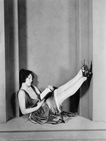 Young Woman Sitting with Her Legs Up and Reading Photo | Art.com