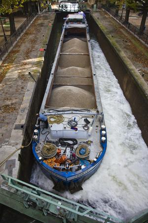 'France, Paris, Canal St-Martin, barge and bargeman (NR) in canal locks ...