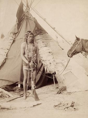 'A Native American Stands at the Entrance to His Teepee Holding a Rifle ...